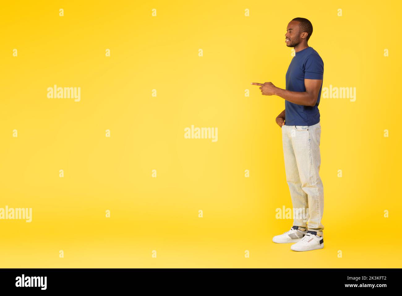 Side View Of African Male Pointing Finger Aside, Yellow Background ...
