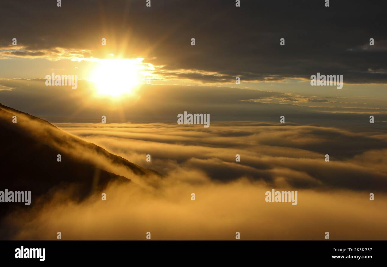 Sunset at the top of the mountain, below a sea of clouds Stock Photo ...