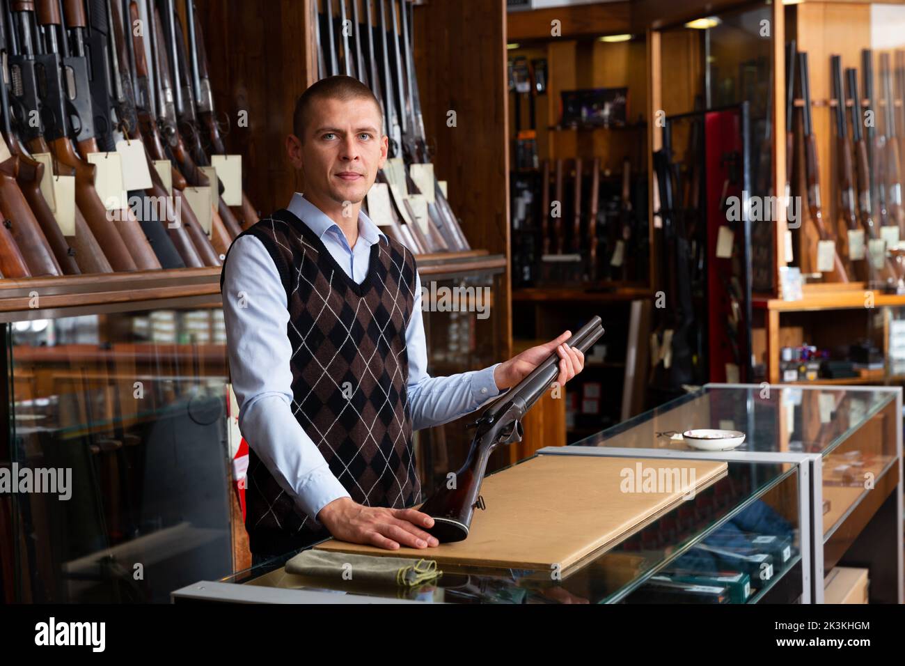 Owner of the gun shop demonstrates rare collectible hunting rifle Stock ...