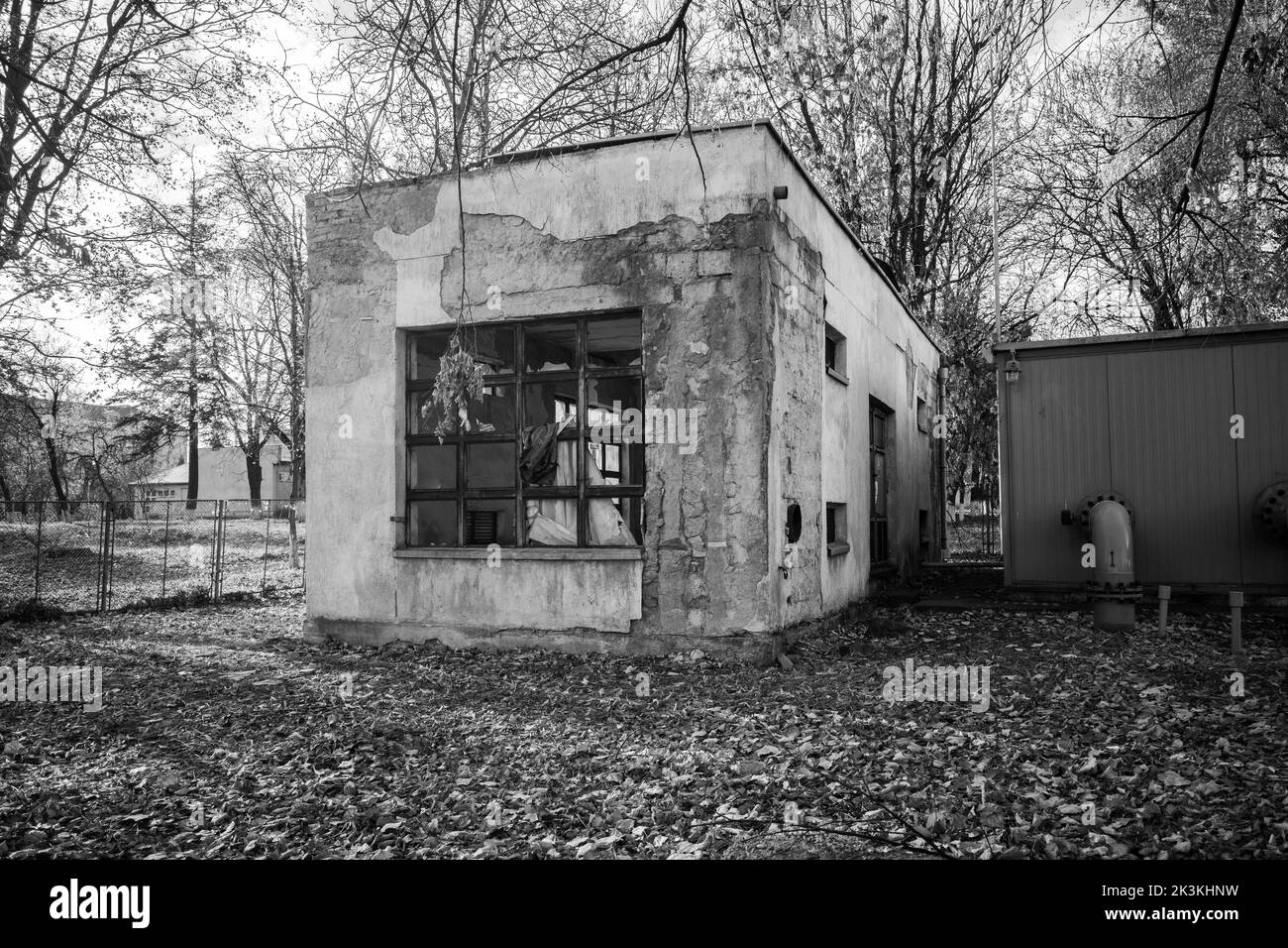 An abandoned building with broken walls and window under dark clouds ...