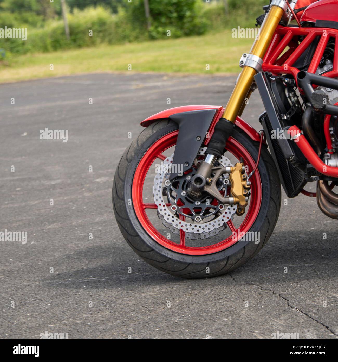 The close-up detailed view of a red motorcycle front wheel on the ...