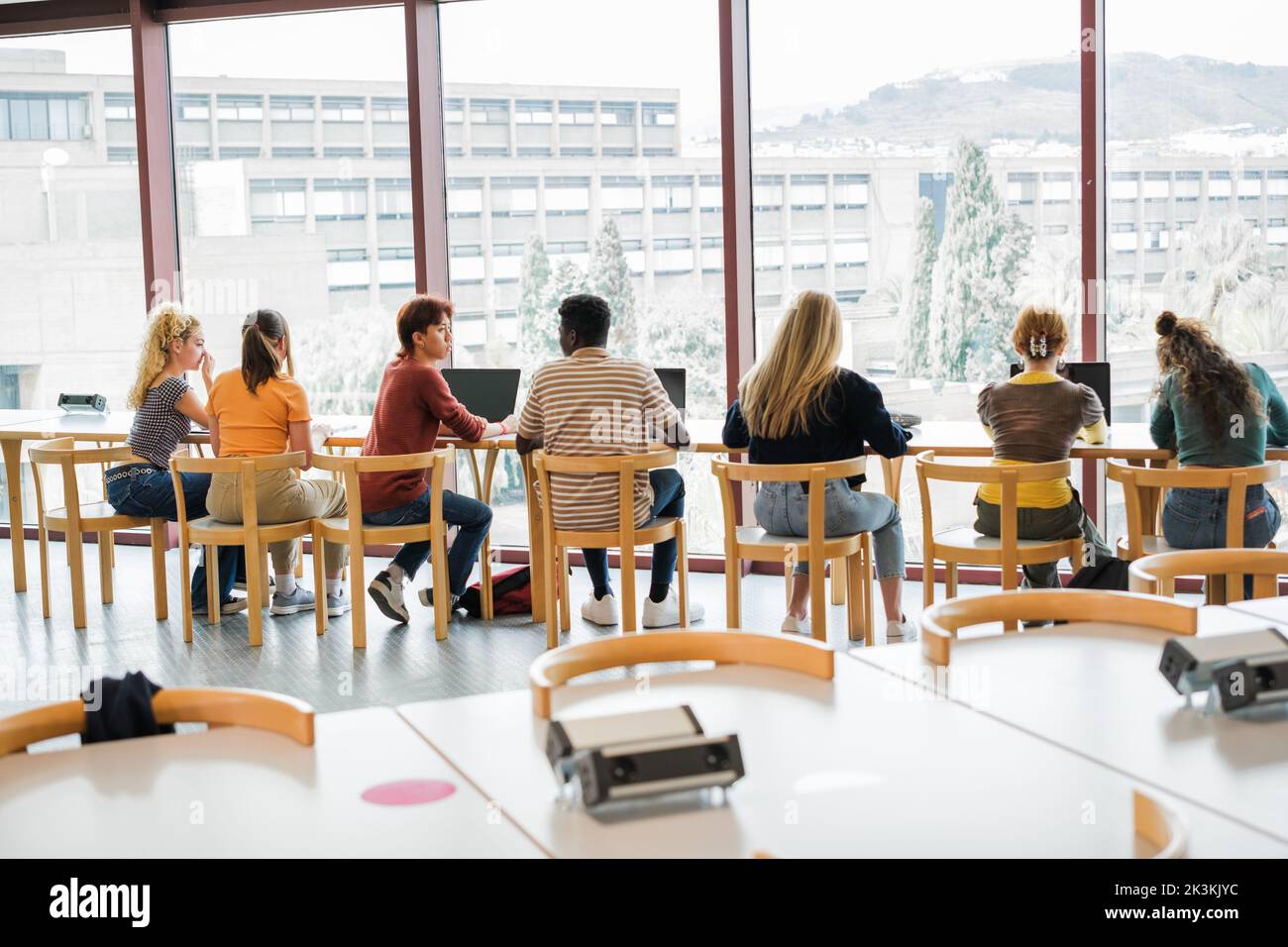 Group of students studying in front of the window of the university ...