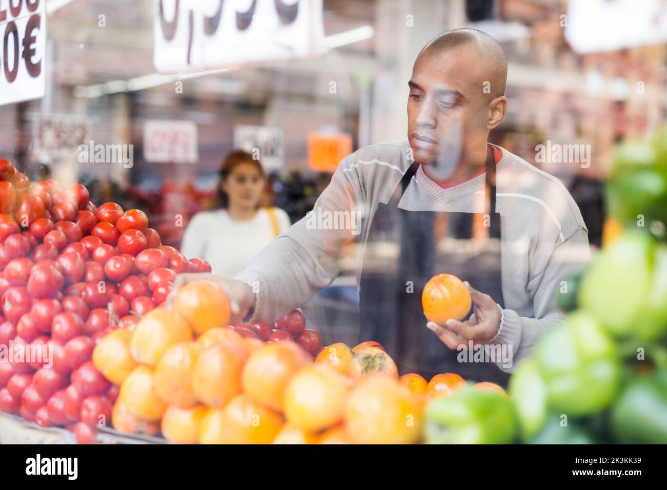 Man working in supermarket near fruit section of oranges Stock Photo ...