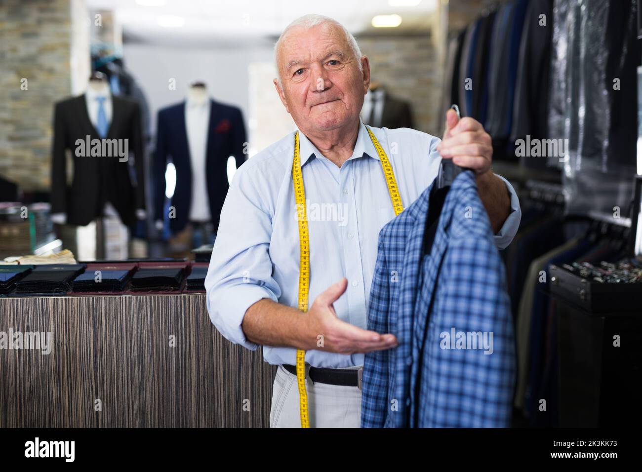 Male tailor demonstrating of fashionable suit in apparel shop Stock ...