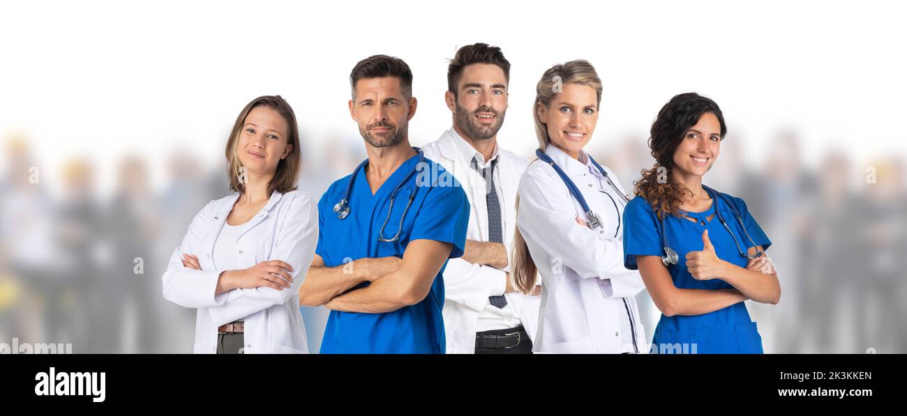 Team of five doctors standing in front of crowd of many people patient ...