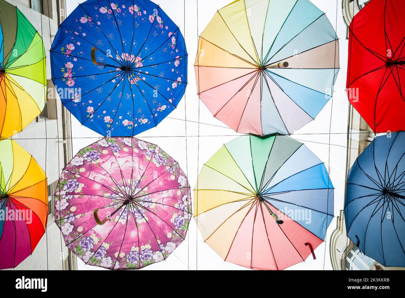 A view from the bottom of colorful umbrellas cover in narrow city alley ...