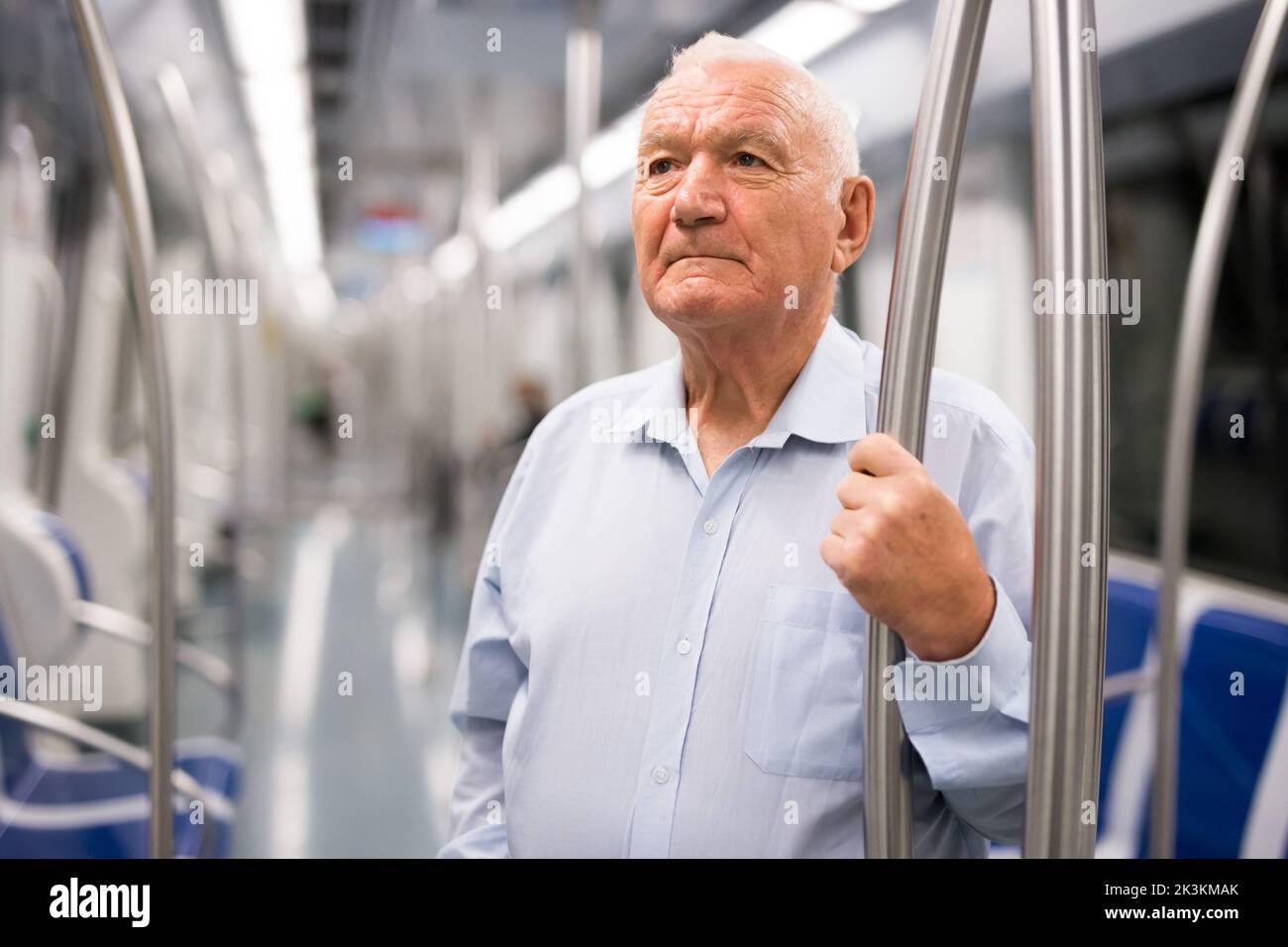 Old man standing in subway car Stock Photo - Alamy