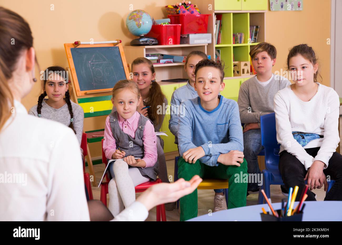 children sitting and listening teacher Stock Photo - Alamy