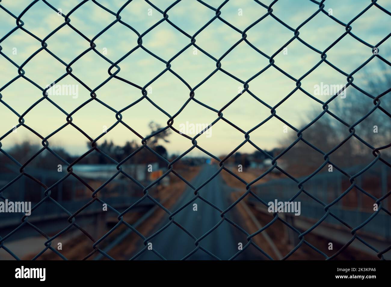 A view of the road through a chain fence Stock Photo - Alamy