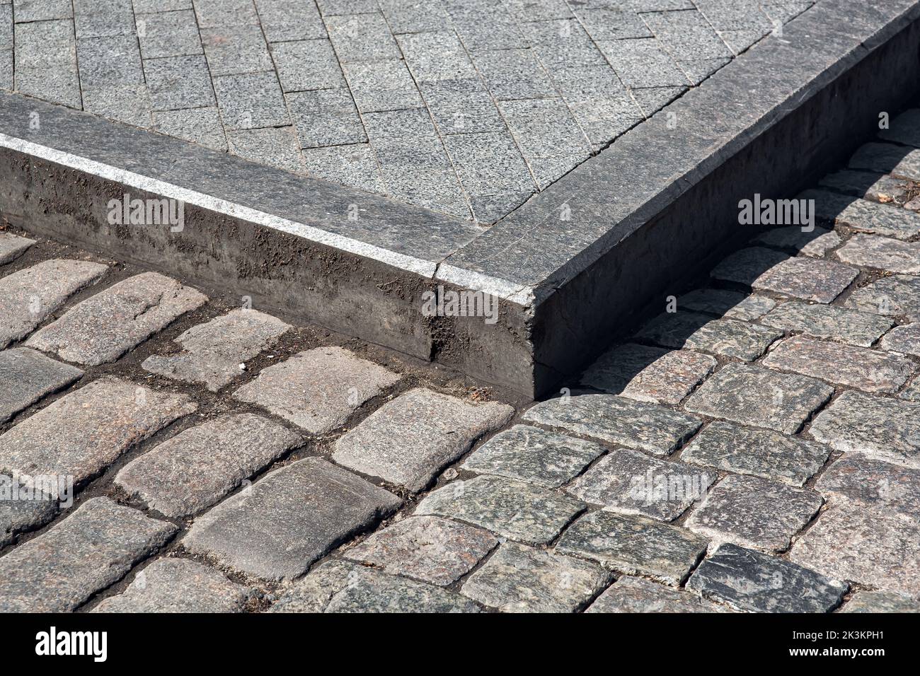 corner of a pedestrian sidewalk made of stone rectangular brick tiles ...