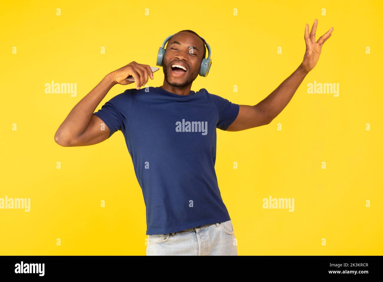 Black Male Singer Singing Holding Smartphone Like Microphone, Yellow ...