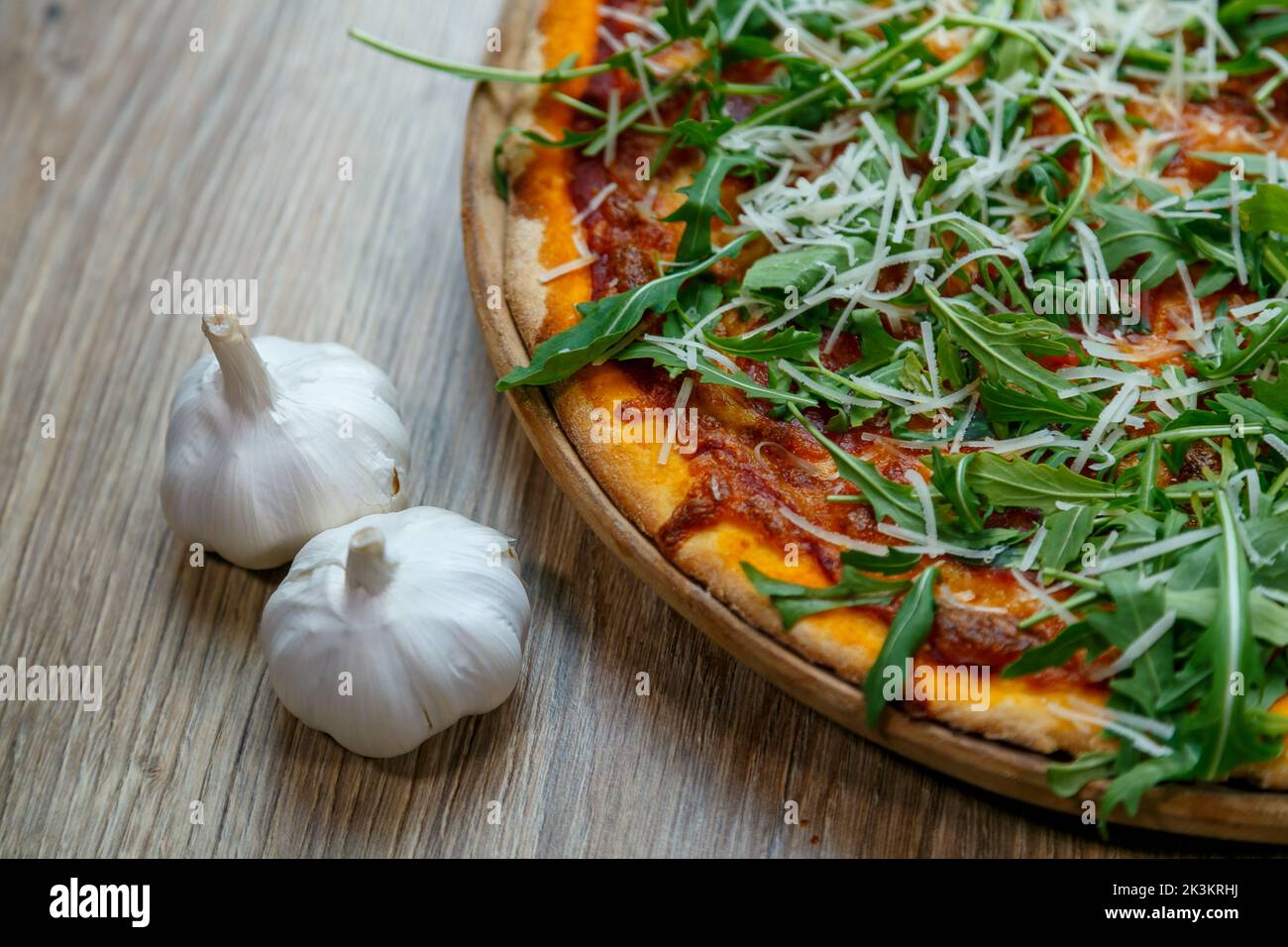 A tasty pizza with ham,arugula,tomato sauce and shredded mozzarella ...