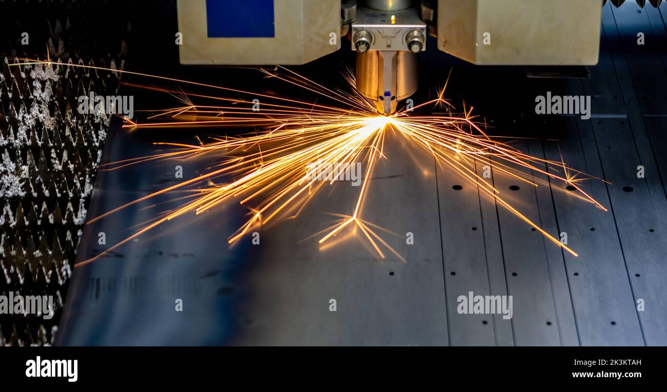 An automated stainless steel cutting machine produces sparks while in ...