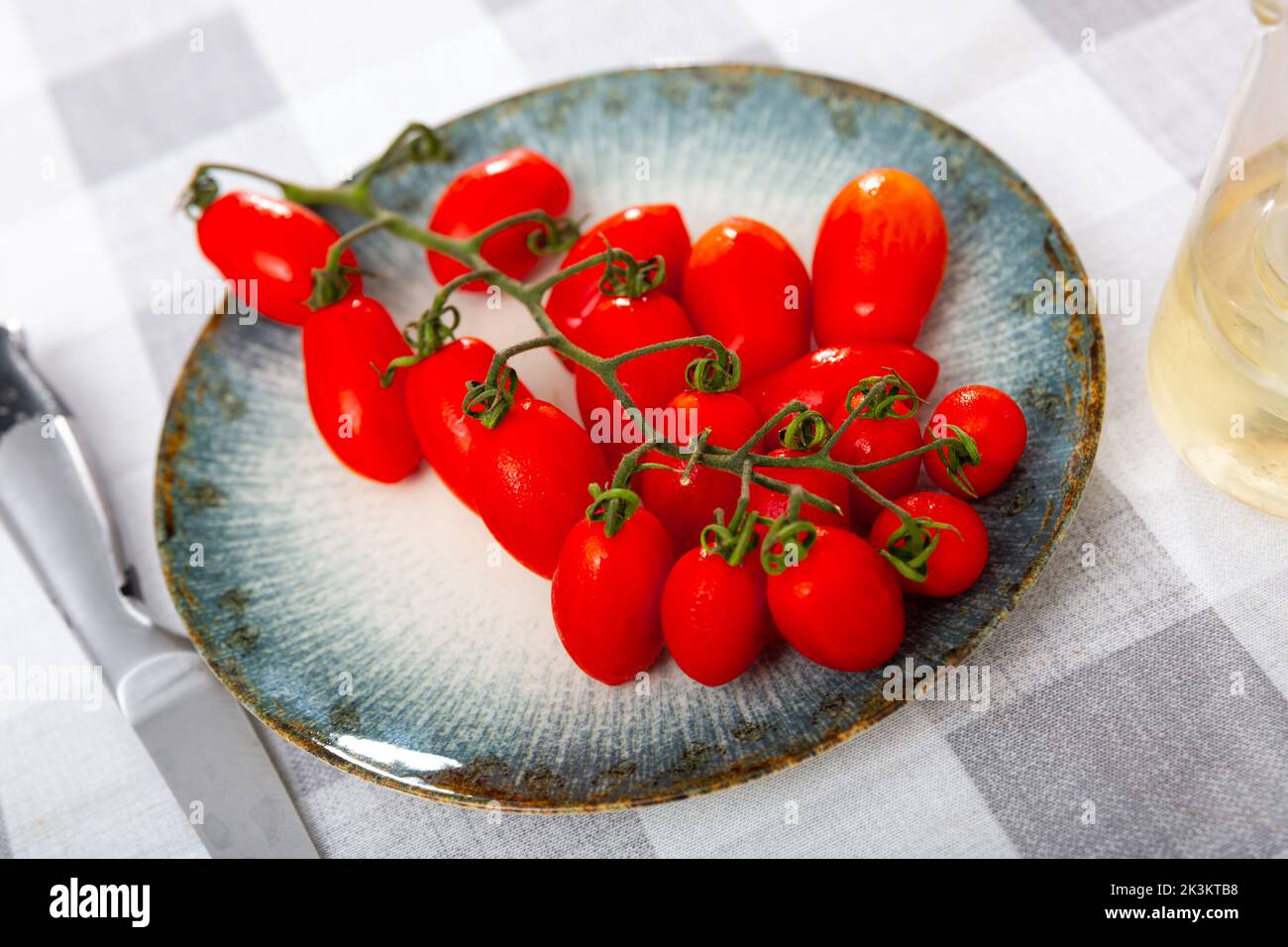 Fresh bunch of cherry tomatoes on plate on table Stock Photo - Alamy