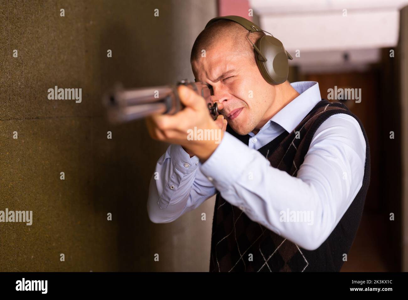 Focused man aiming shotgun at target in shooting range Stock Photo - Alamy