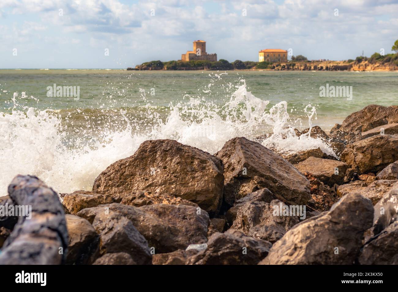 waves splash on the beach in front of the castle Torre Astura, Rome ...