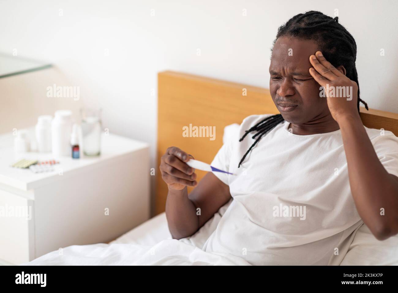 Sick Young African American Man Holding Thermometer While Sitting In ...