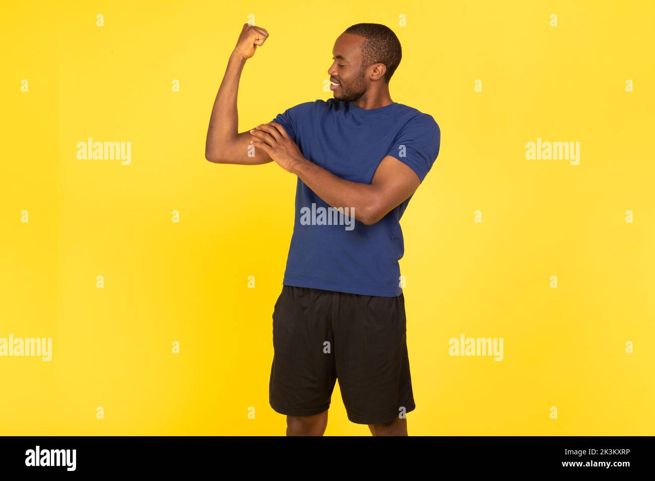 Sporty African American Guy Showing Biceps Muscles On Yellow Background ...