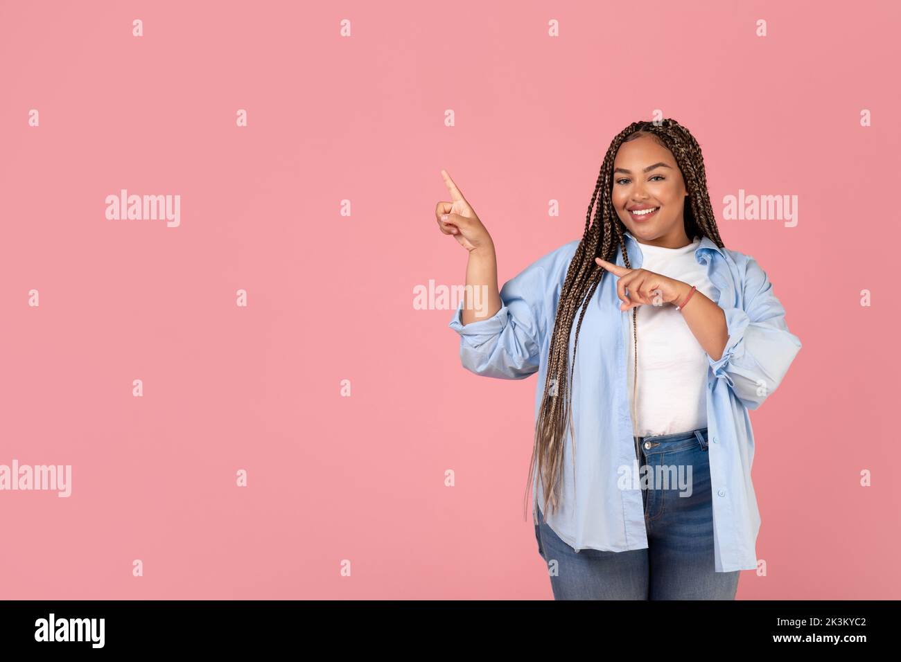 African Woman Pointing Fingers Aside At Copy Space, Pink Background ...