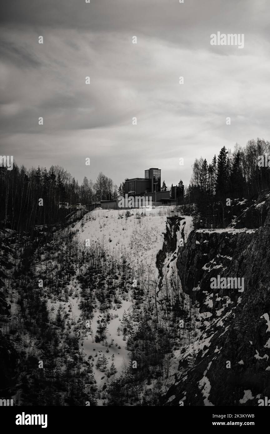 A grayscale of an open-pit mine with laboratory building on a cloudy ...