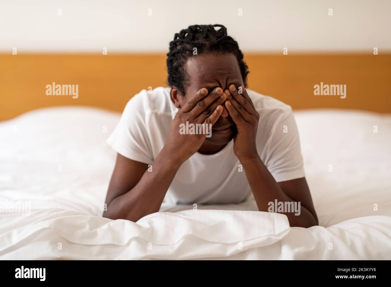 Tired African American Man Rubbing Eyes While Waking Up In Bed Stock