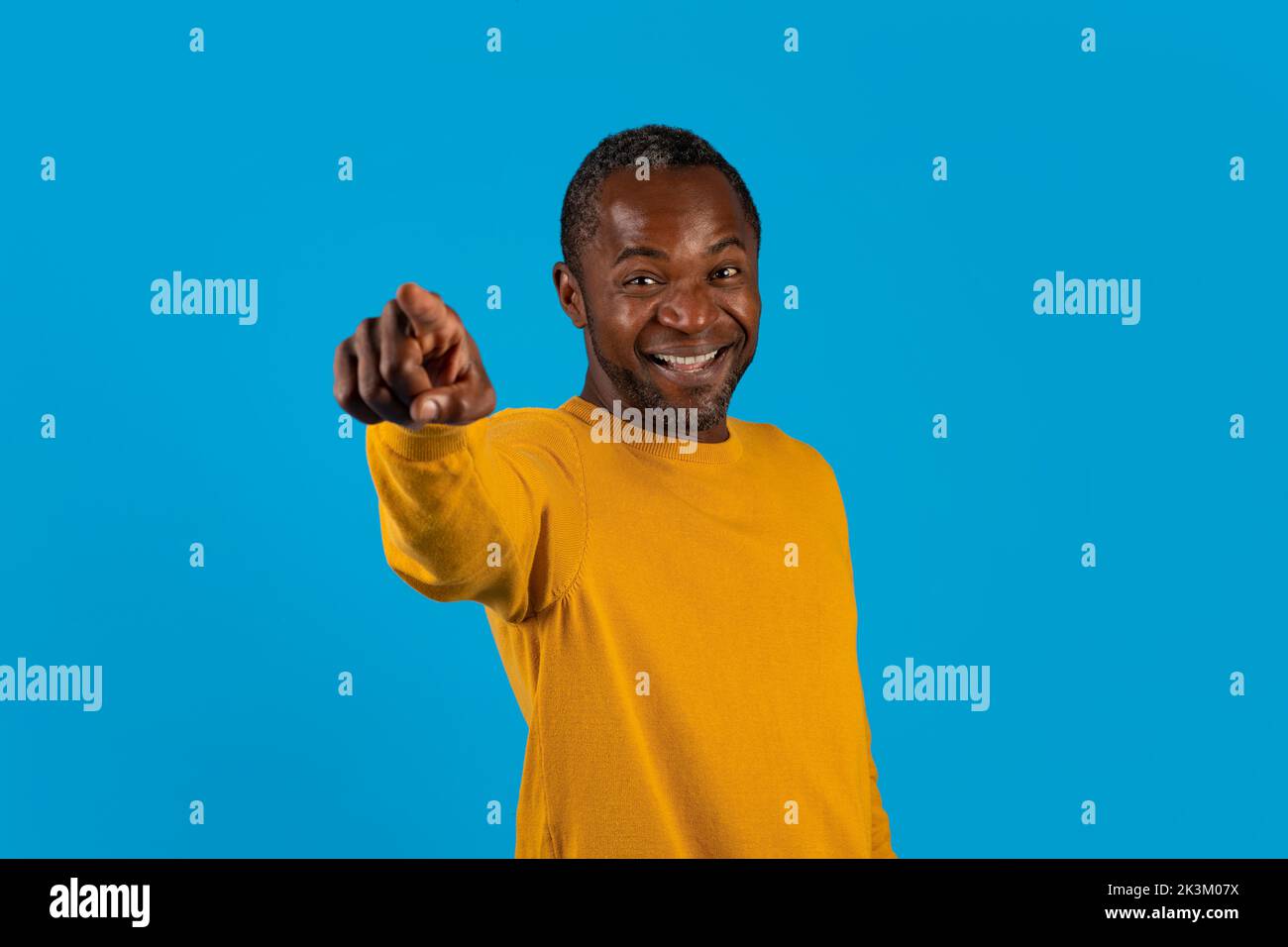 Positive black man pointing at camera and smiling Stock Photo - Alamy