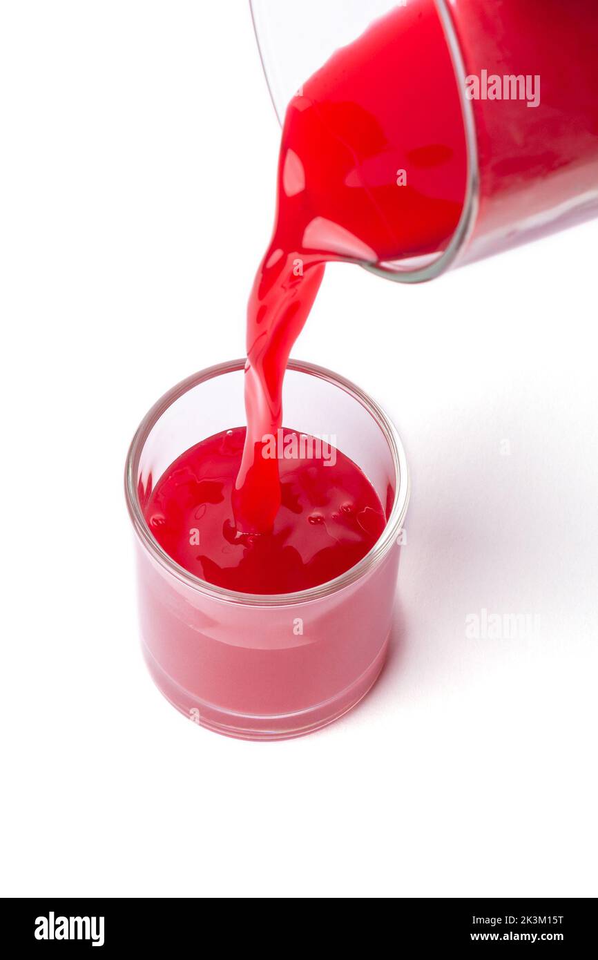red color drink or juice pouring into glass, close-up of beverage ...