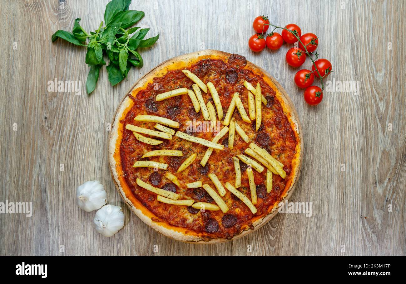 A top view of Pizza Patatosa with hot sausage and french fries in ...