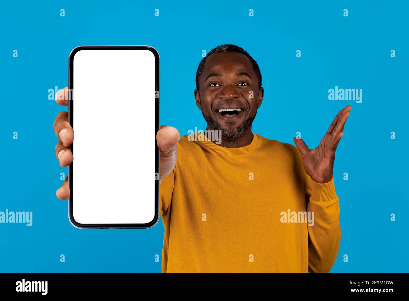 Excited black man showing smartphone with empty screen Stock Photo - Alamy