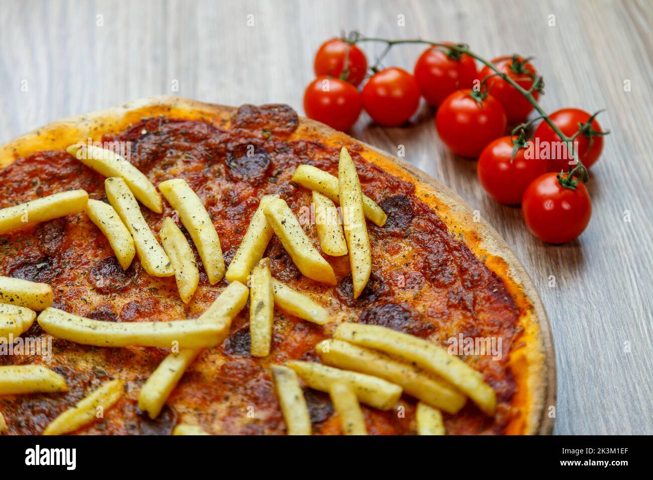 A tasty Pizza Patatosa with hot sausage and french fries in tomato ...
