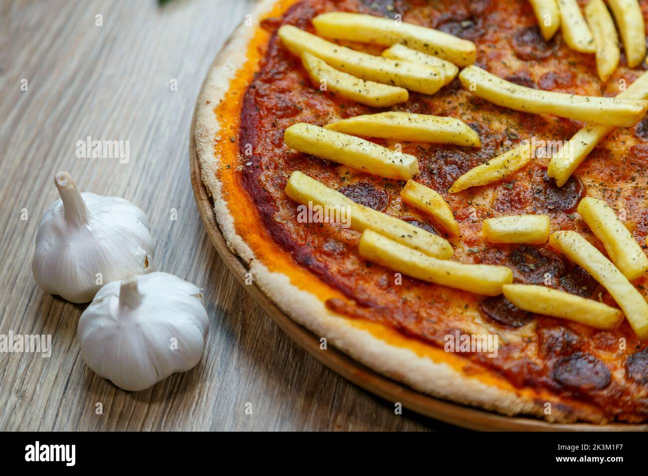 A top view of Pizza Patatosa with hot sausage and french fries in ...