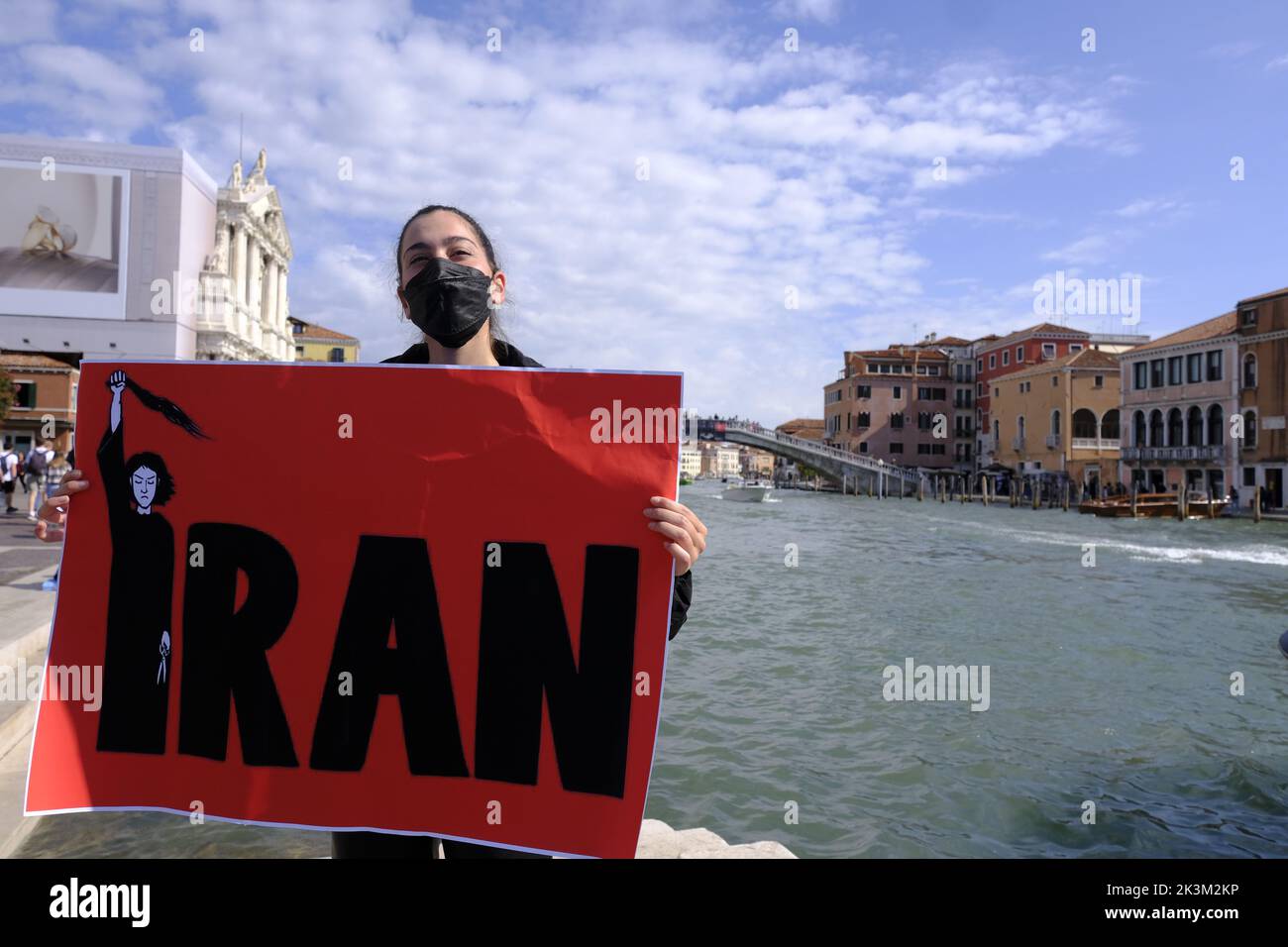 Iranian girls protest in front of Venice train station displaying a ...