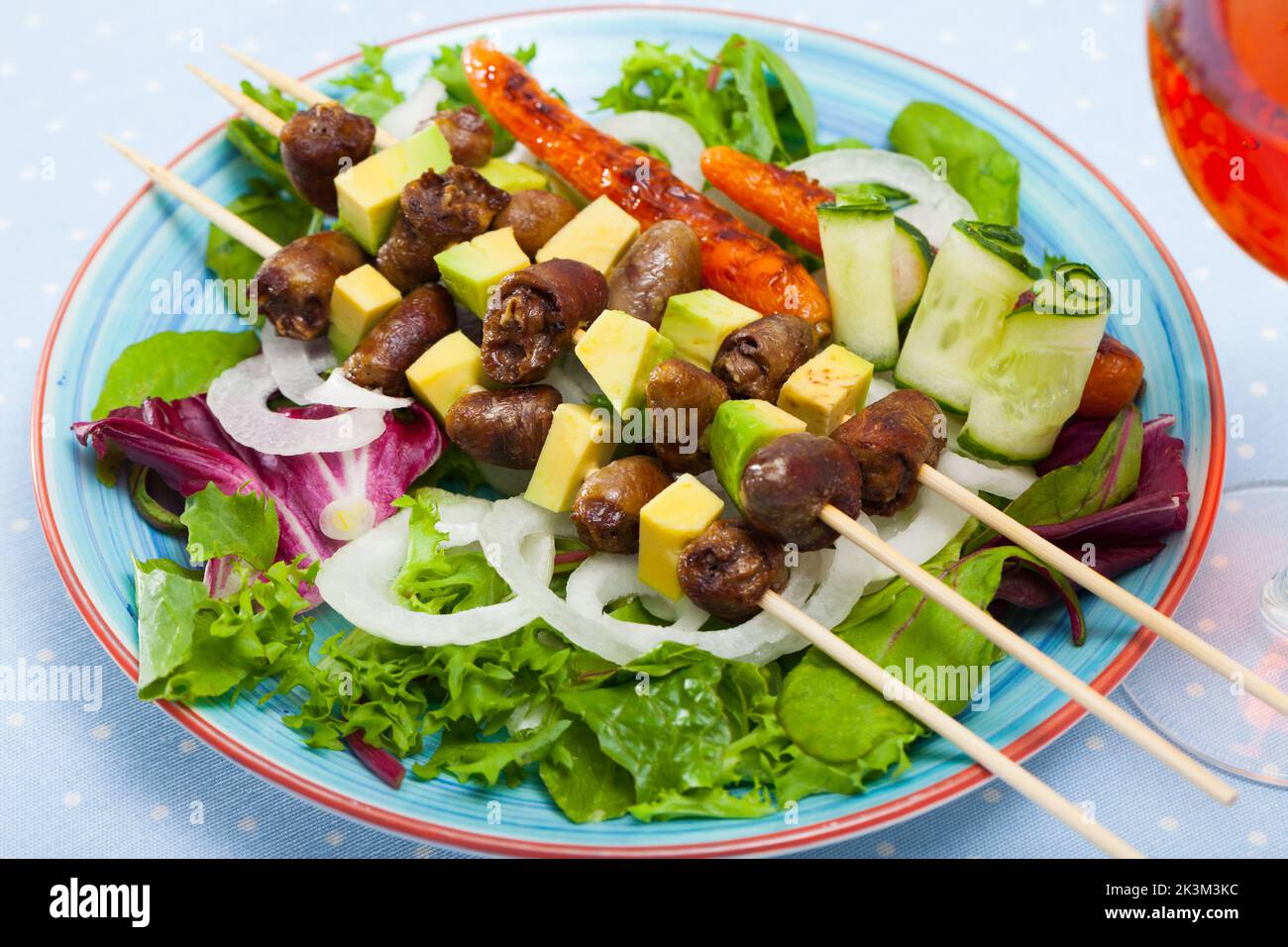 Fried shish kebab from chicken hearts served with avocado and fresh ...