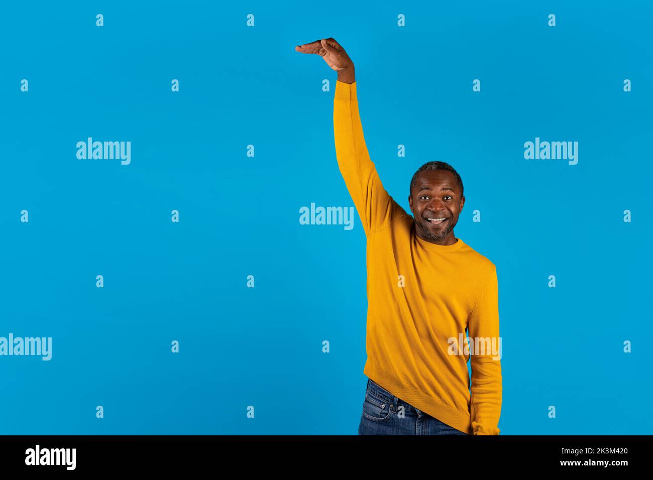 Happy african american man showing height of something invisible Stock ...
