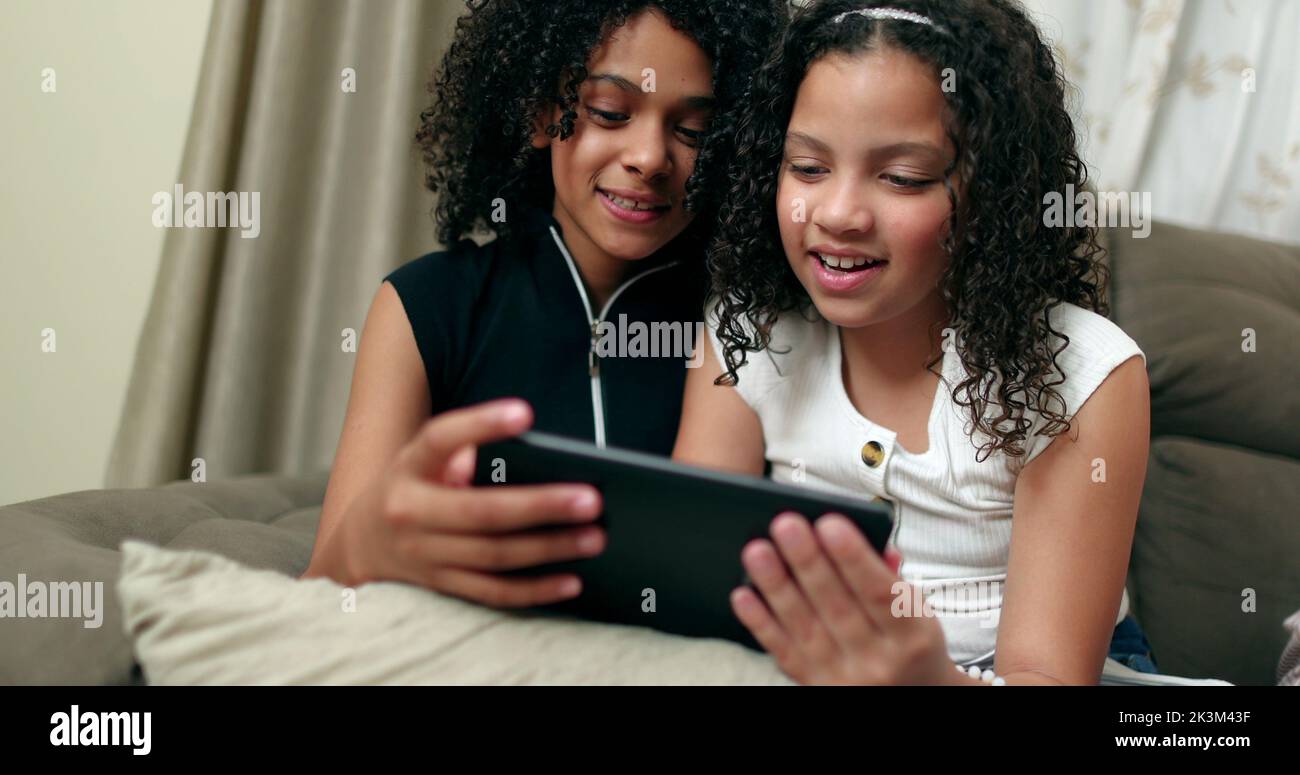 Two little girls using smartphone device at home. Preteen friends ...