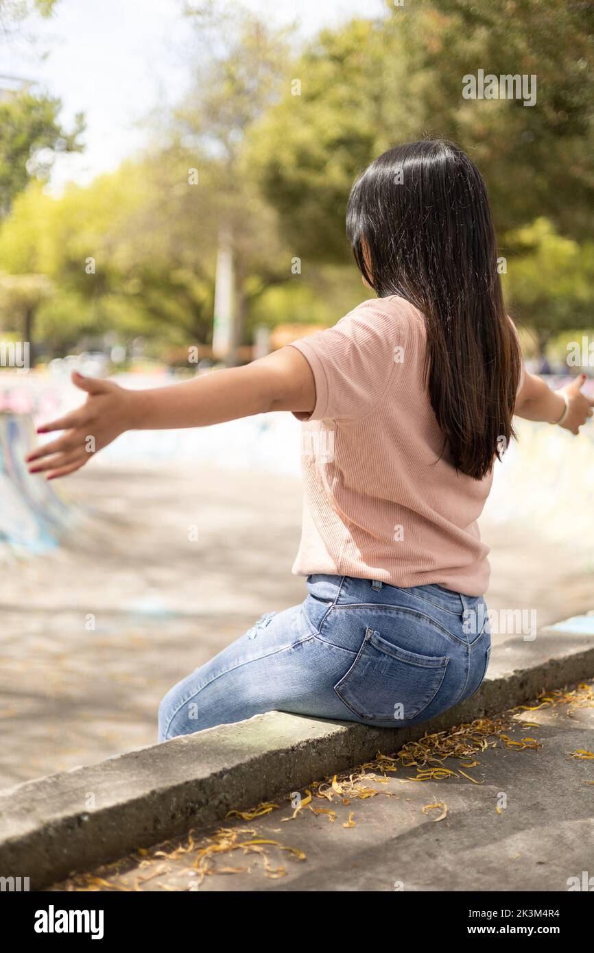 sitting on her back opening her arms a woman with long straight hair ...