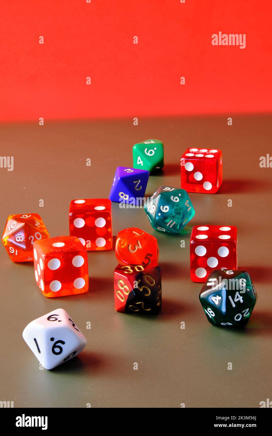 Different role playing dice on top of a table with a red background ...