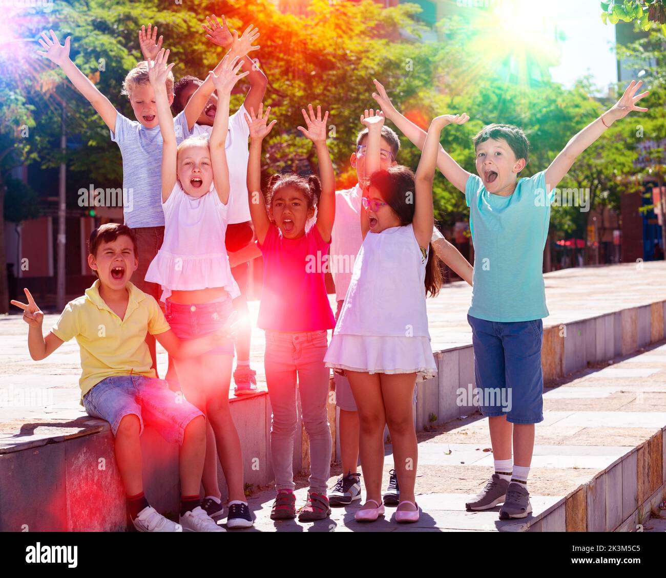 Positive children holding hands up and smiling together in park Stock ...