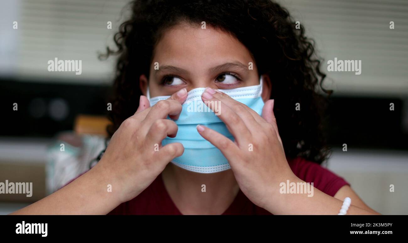Little girl putting covid face mask. Preteen child wearing surgical ...