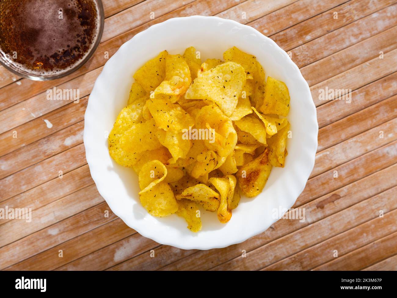 Potato chips served with glass of beer Stock Photo - Alamy