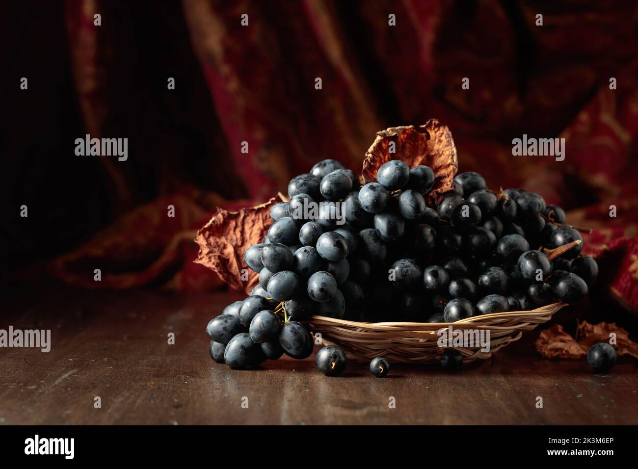 Bunch of blue grapes on an old wooden table Stock Photo - Alamy