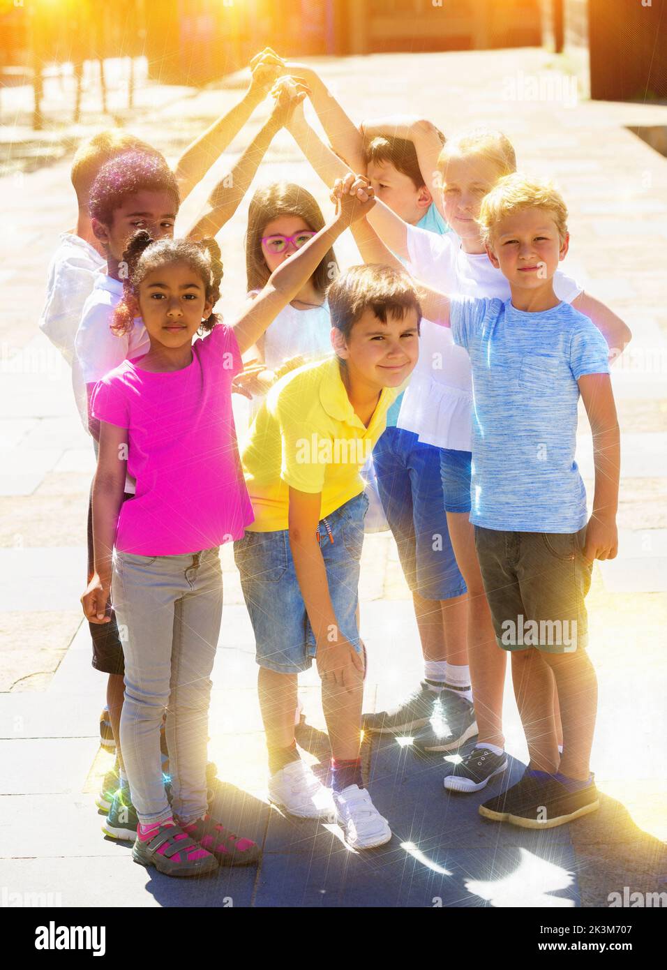 Group of positive children holding hands up and playing together Stock ...