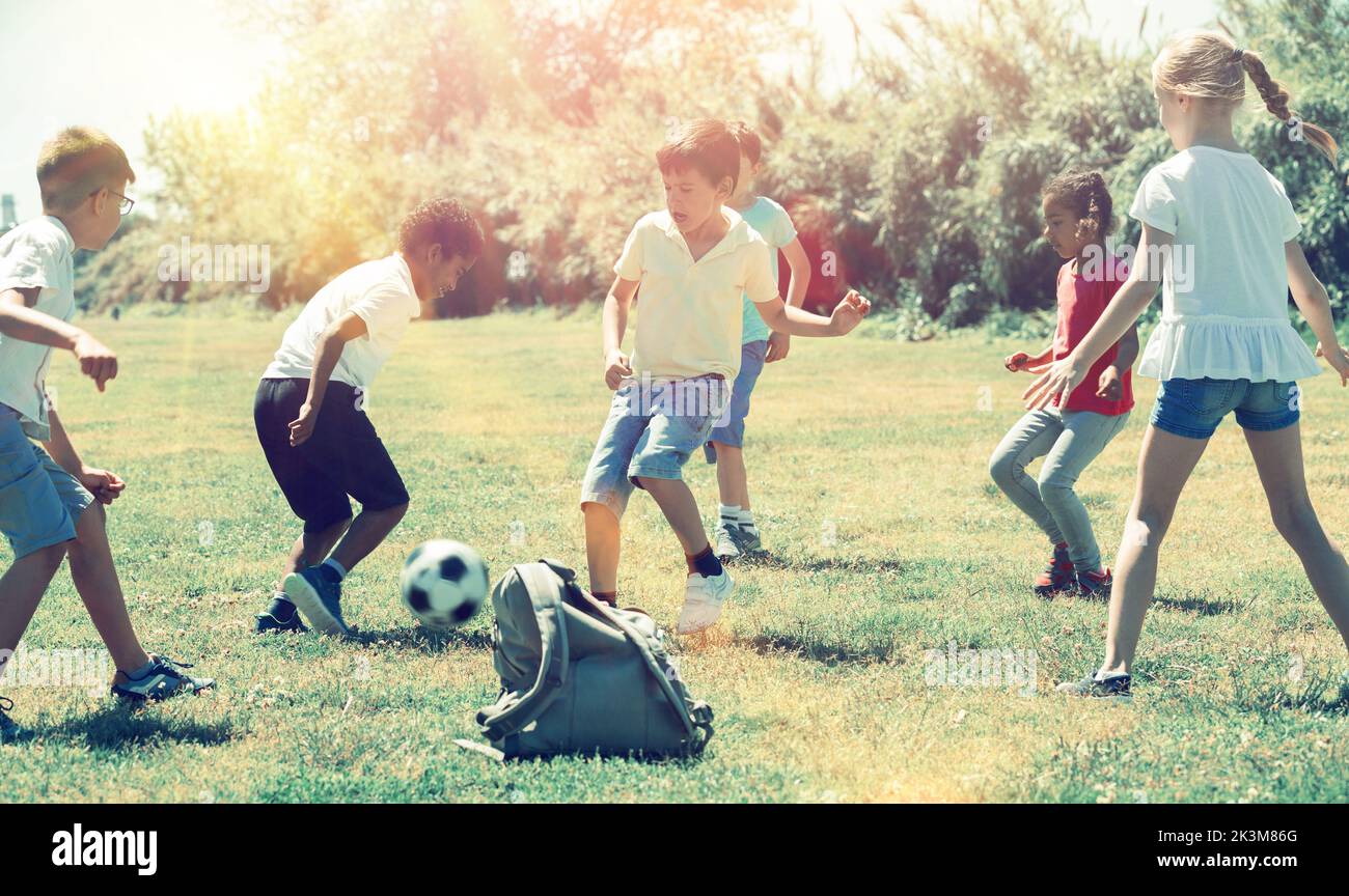 Group of kids are running and playing football in the park Stock Photo ...