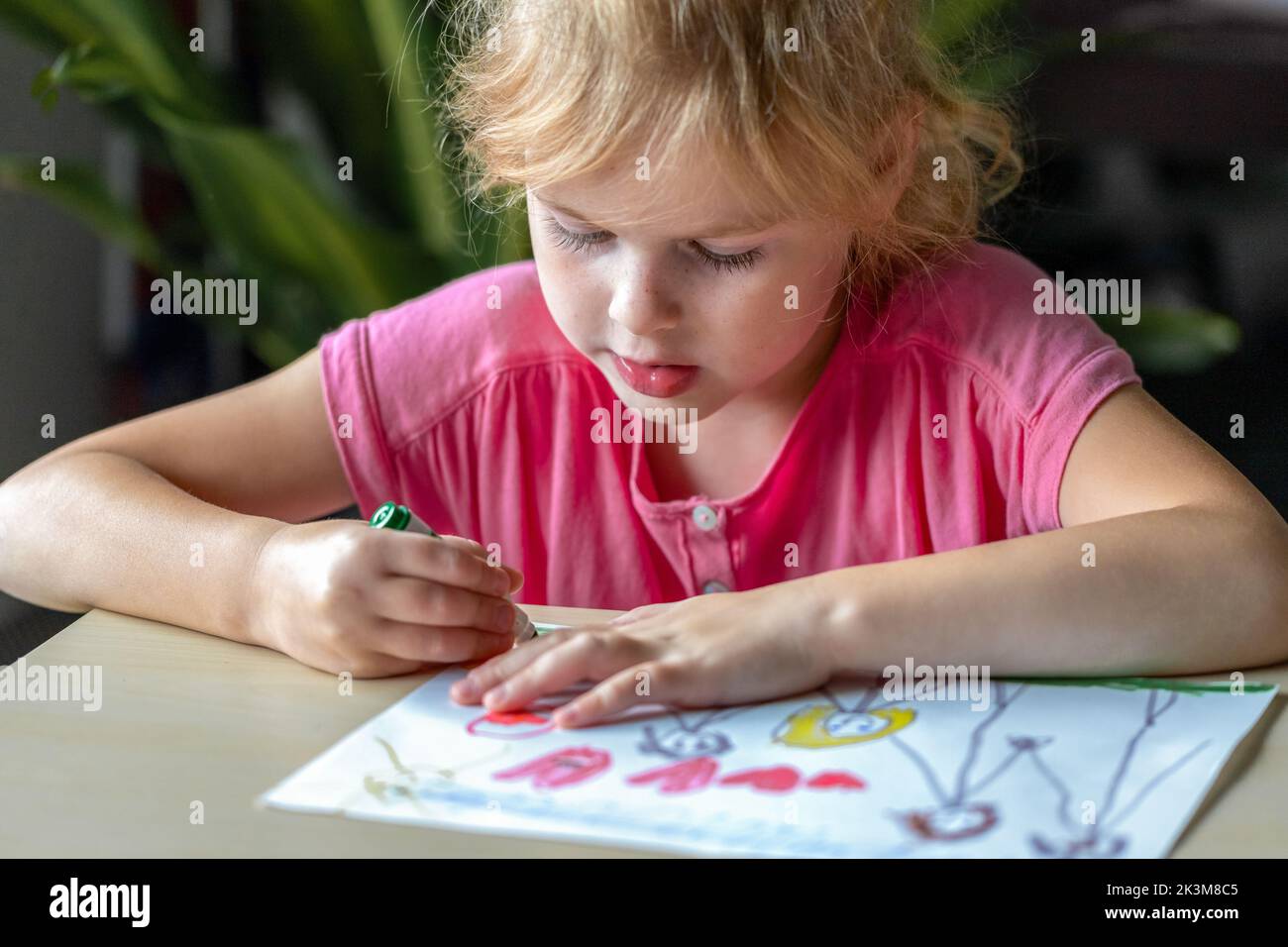 Little girl drawing a picture with colored markers. Child, sitting at ...