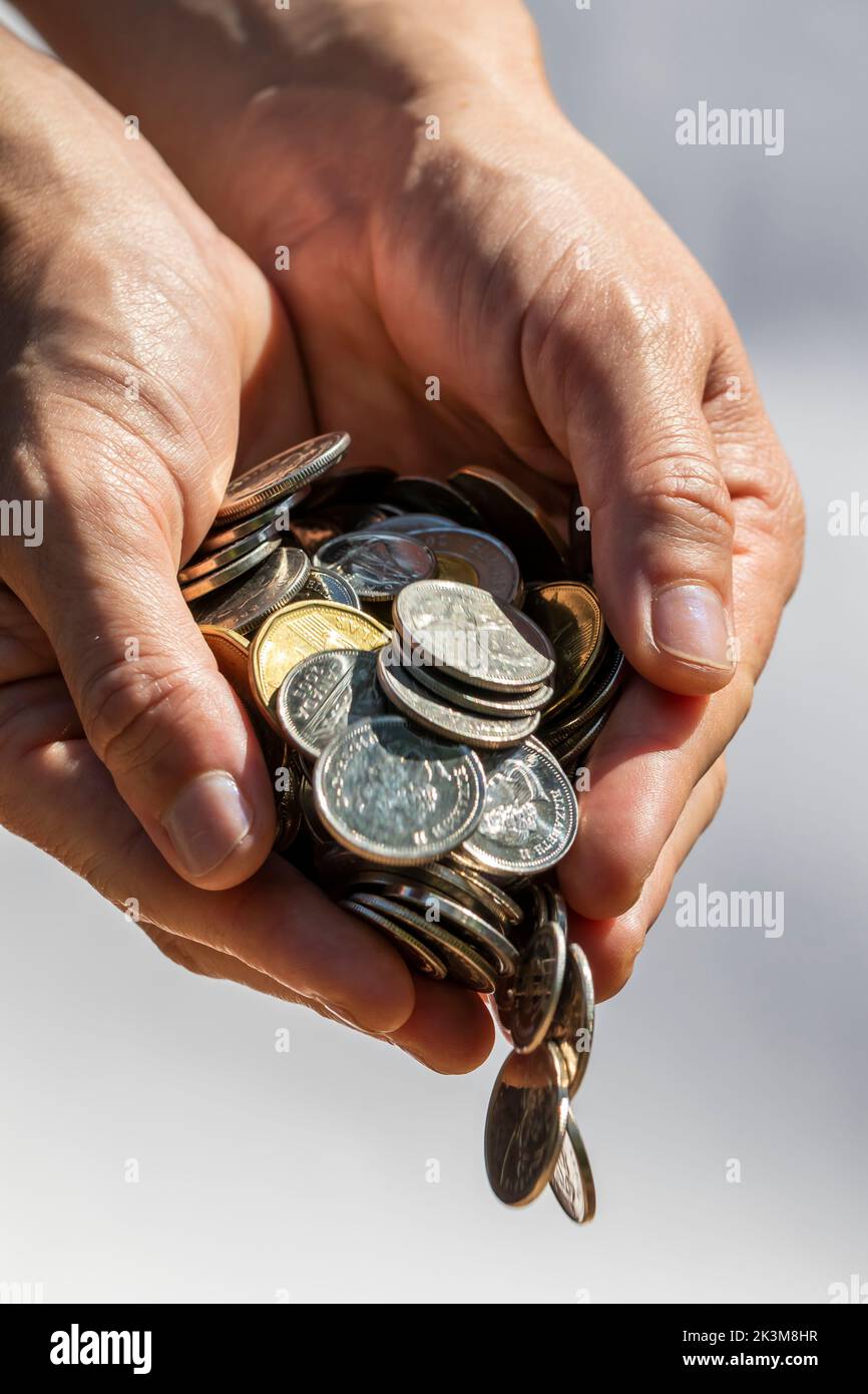 Hands dropping coins hi-res stock photography and images - Alamy