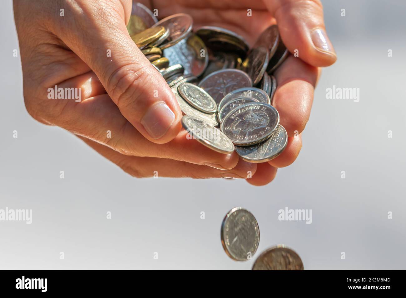 Hands dropping coins hi-res stock photography and images - Alamy