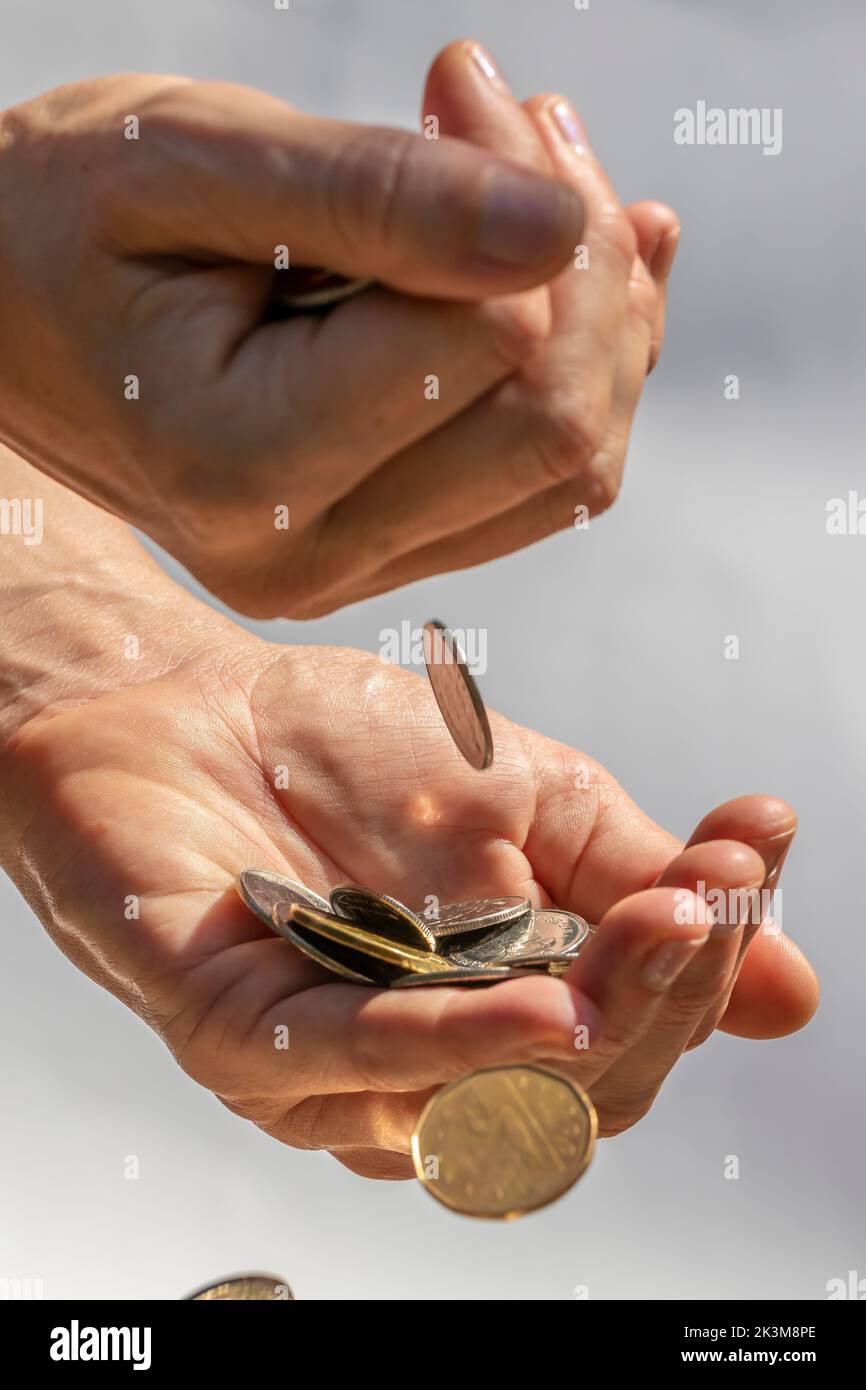 Hands dropping coins hi-res stock photography and images - Alamy