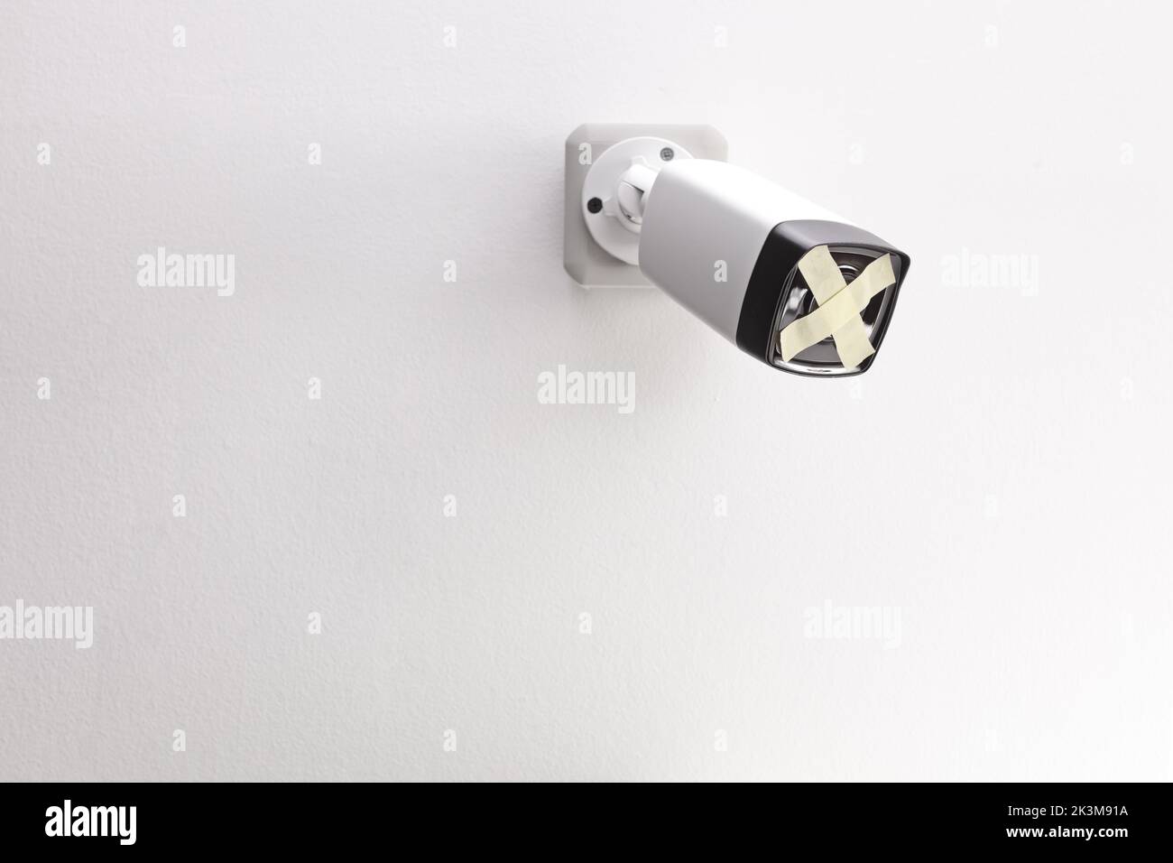 Security camera with a strap over mounted on a wall Stock Photo - Alamy