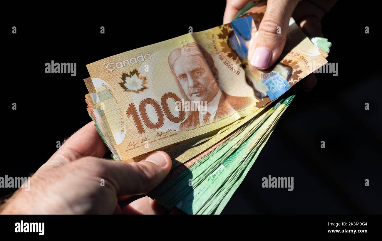 The closeup of hands giving Canadian cash to someone Stock Photo - Alamy