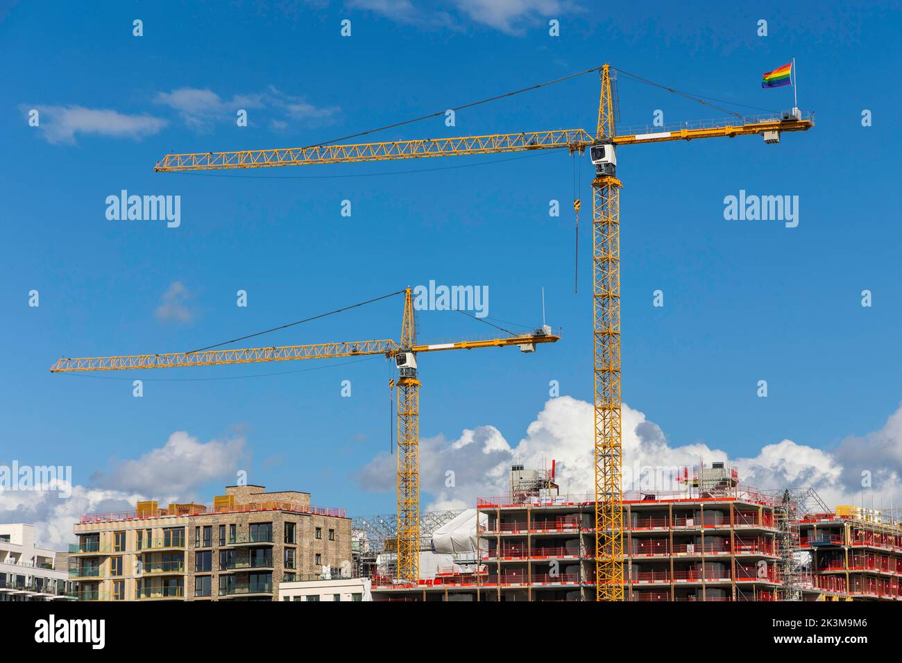 A construction site with two yellow cranes and a big Pride flag Stock ...